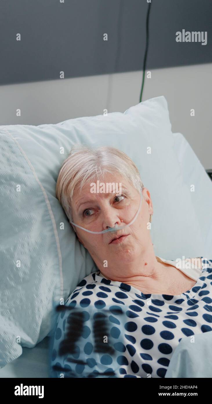 Woman nurse holding x ray scan to old patient for diagnosis and results ...