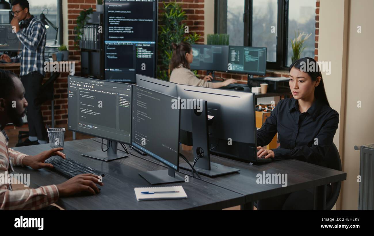 Two focused coders facing each other writing code in software ...