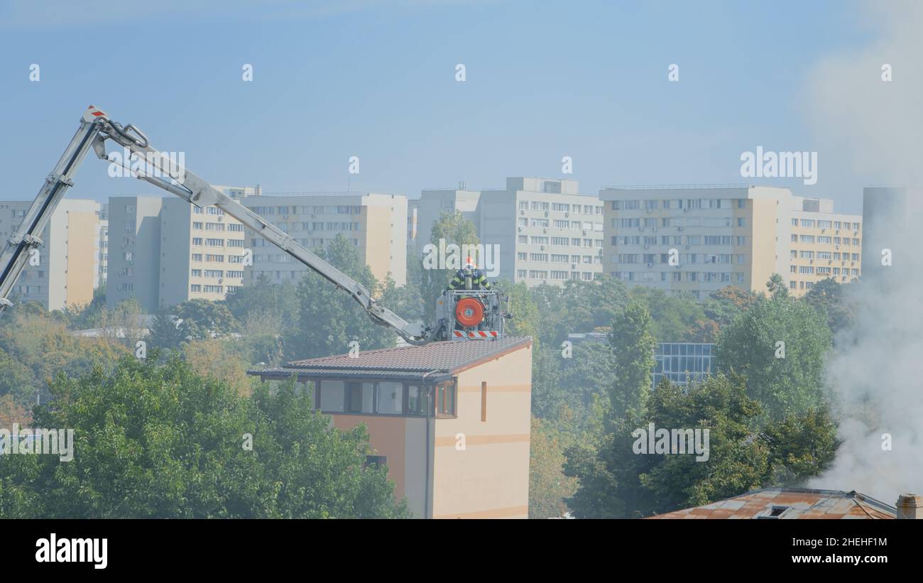 View of firemen using platform truck from fire department to put out ...