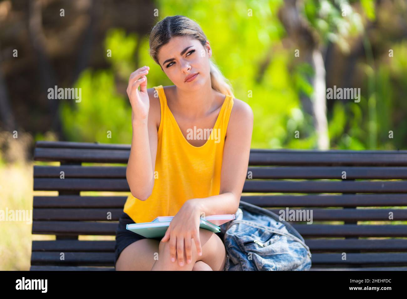 Teenager student girl at outdoors making doubts gesture Stock Photo - Alamy