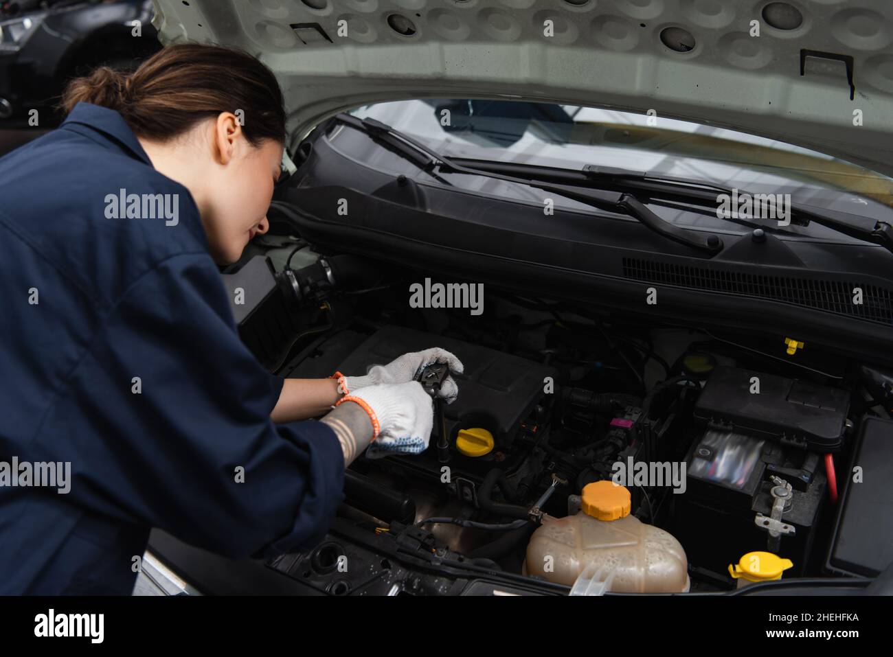 Mechanic working with car engine in garage Stock Photo - Alamy