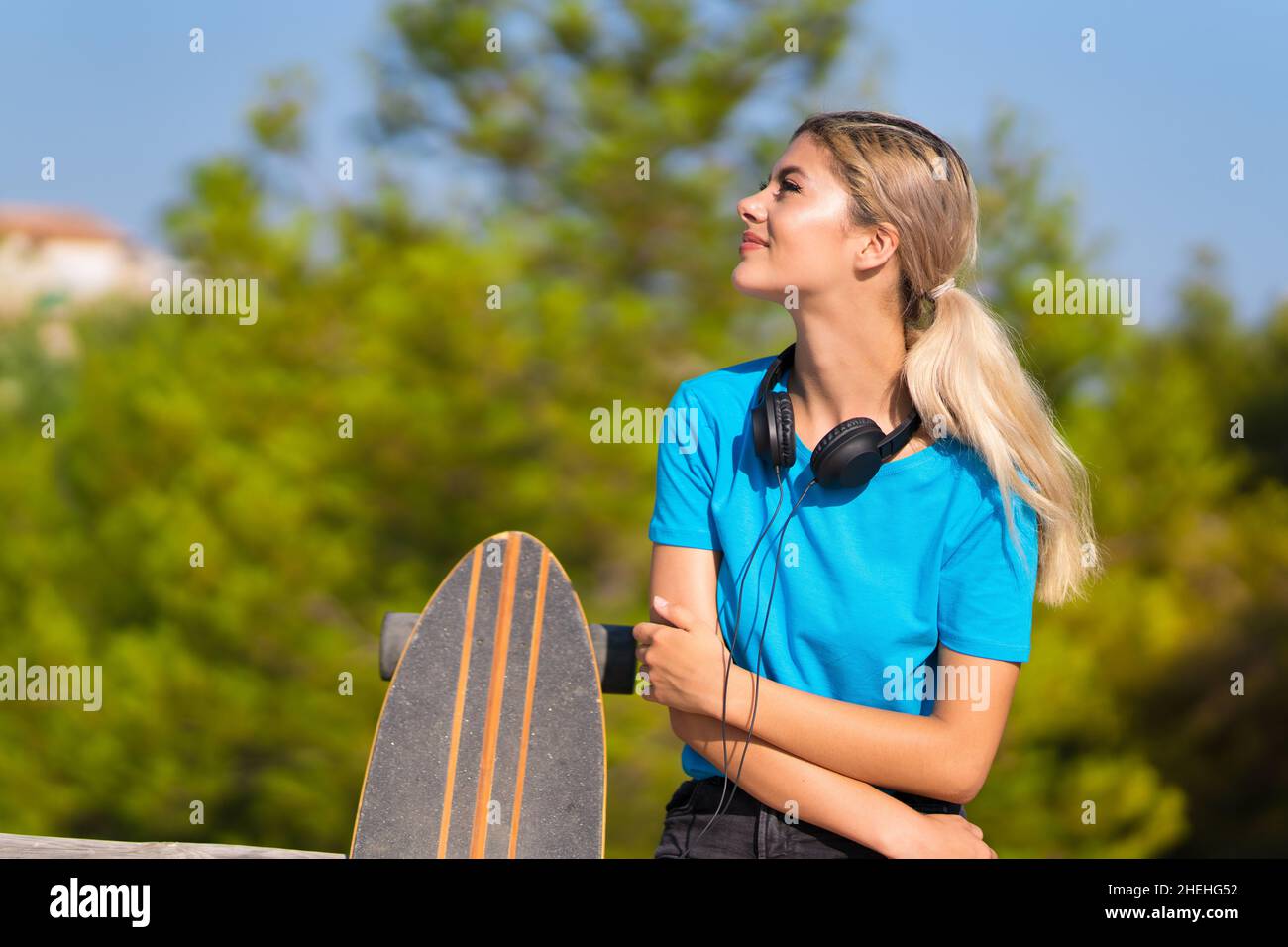 Teenager girl with skate at outdoors happy and smiling Stock Photo - Alamy