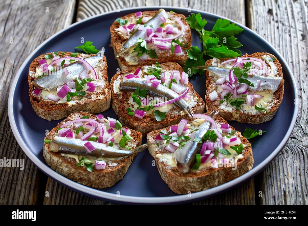 pickled sprat open sandwiches with butter and red onion on rye bread ...