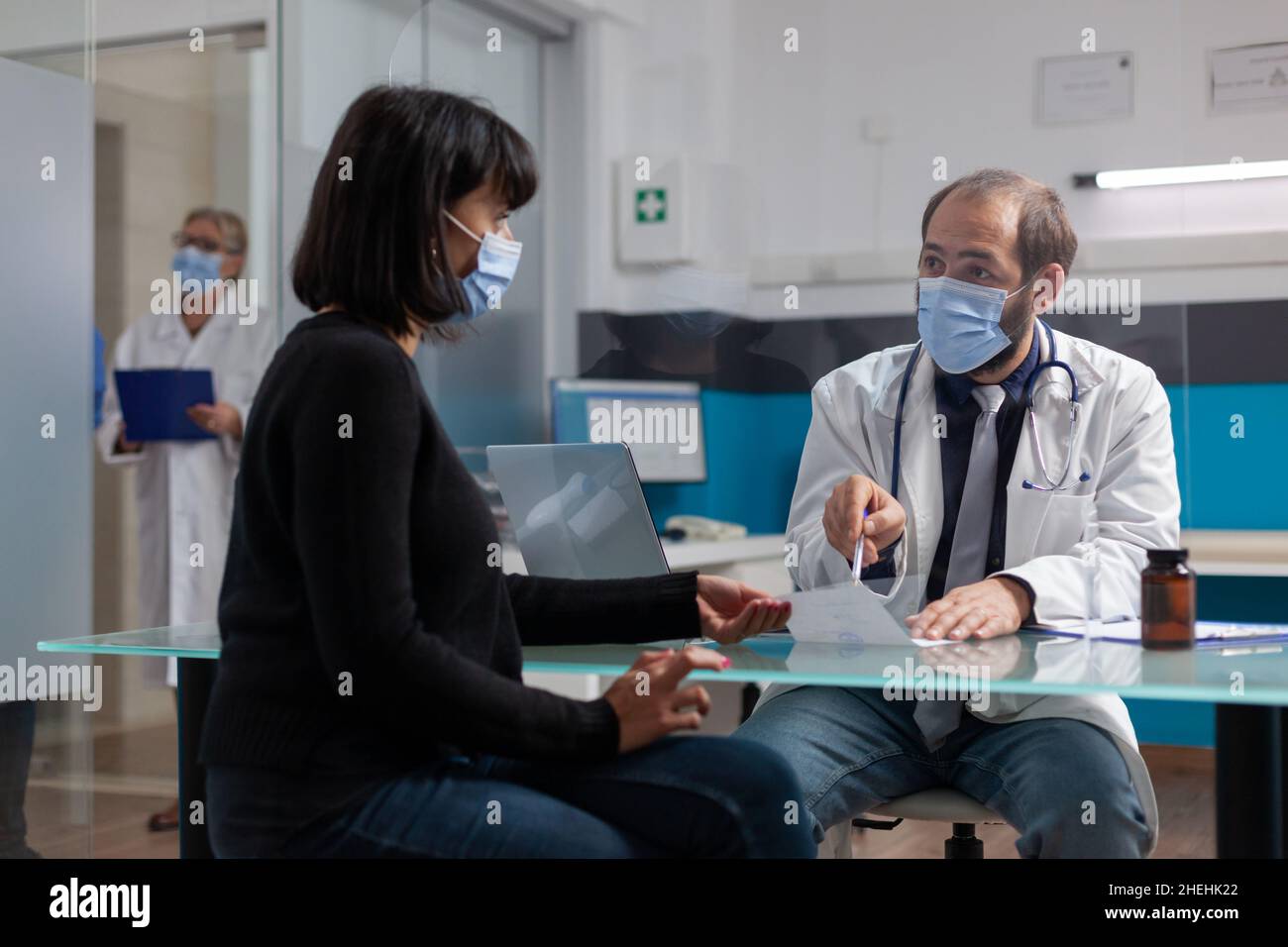 Specialist giving prescription paper with medicine to woman, signing ...