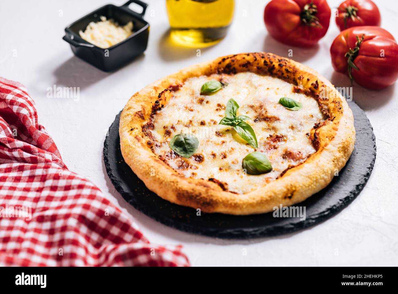 Traditional italian pizza on a white rustic background with basil ...