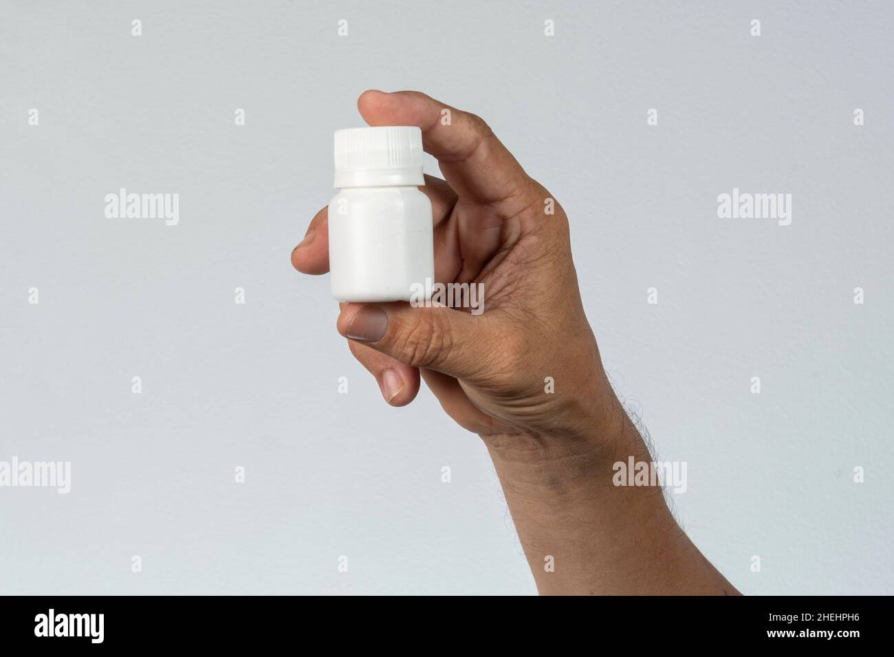 hand holding plastic medicine box in a gray background Stock Photo - Alamy