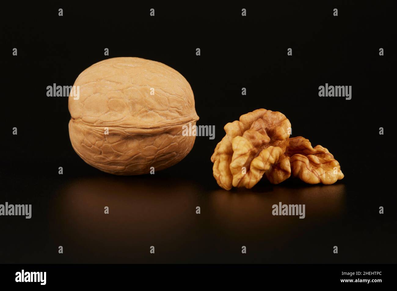 A whole walnut, and next to it is a peeled nut kernel Stock Photo - Alamy