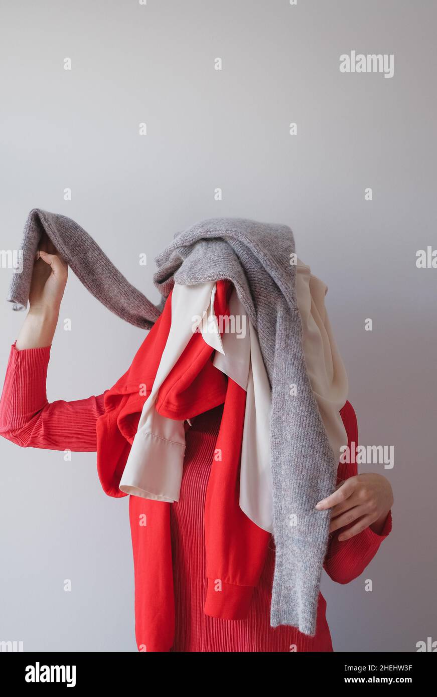 woman with lots of clothes over her head. ecology, fast fashion and ...