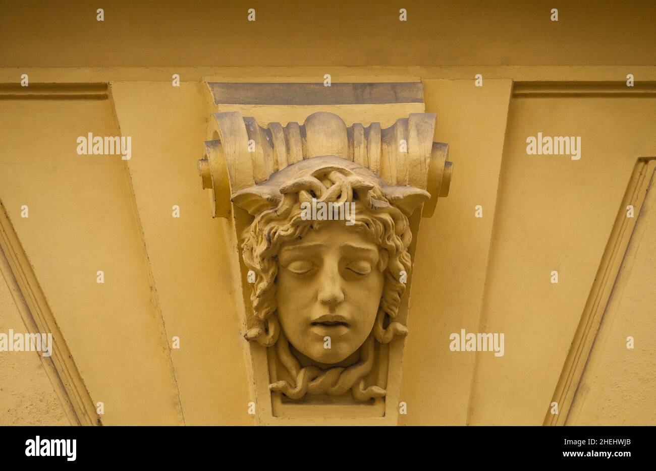 Medusa head as a decoration on the yellow facade of an old historic ...