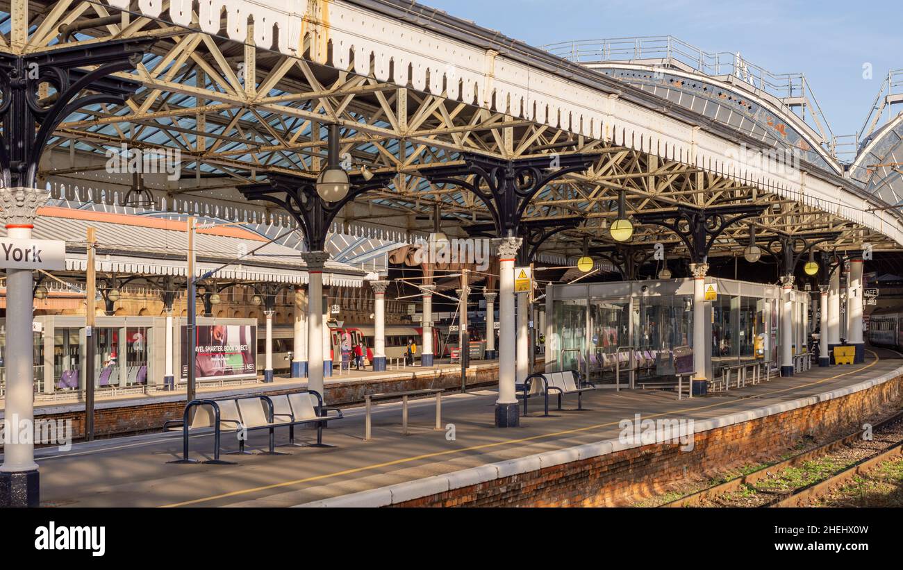 Railway station platform with a waiting room to one side. Overhead is ...