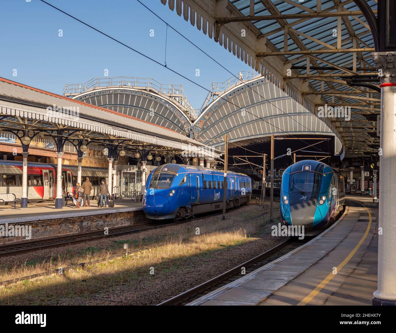 Railway station platform with a train alongside. Overhead is an ...