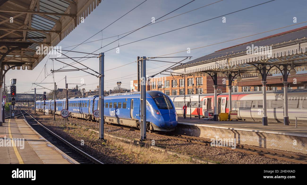 Historic railway station platform with trains alongside. A signal light ...