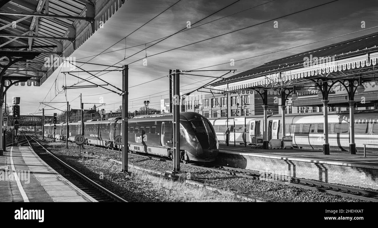 Historic railway station platform with trains alongside. A signal light ...