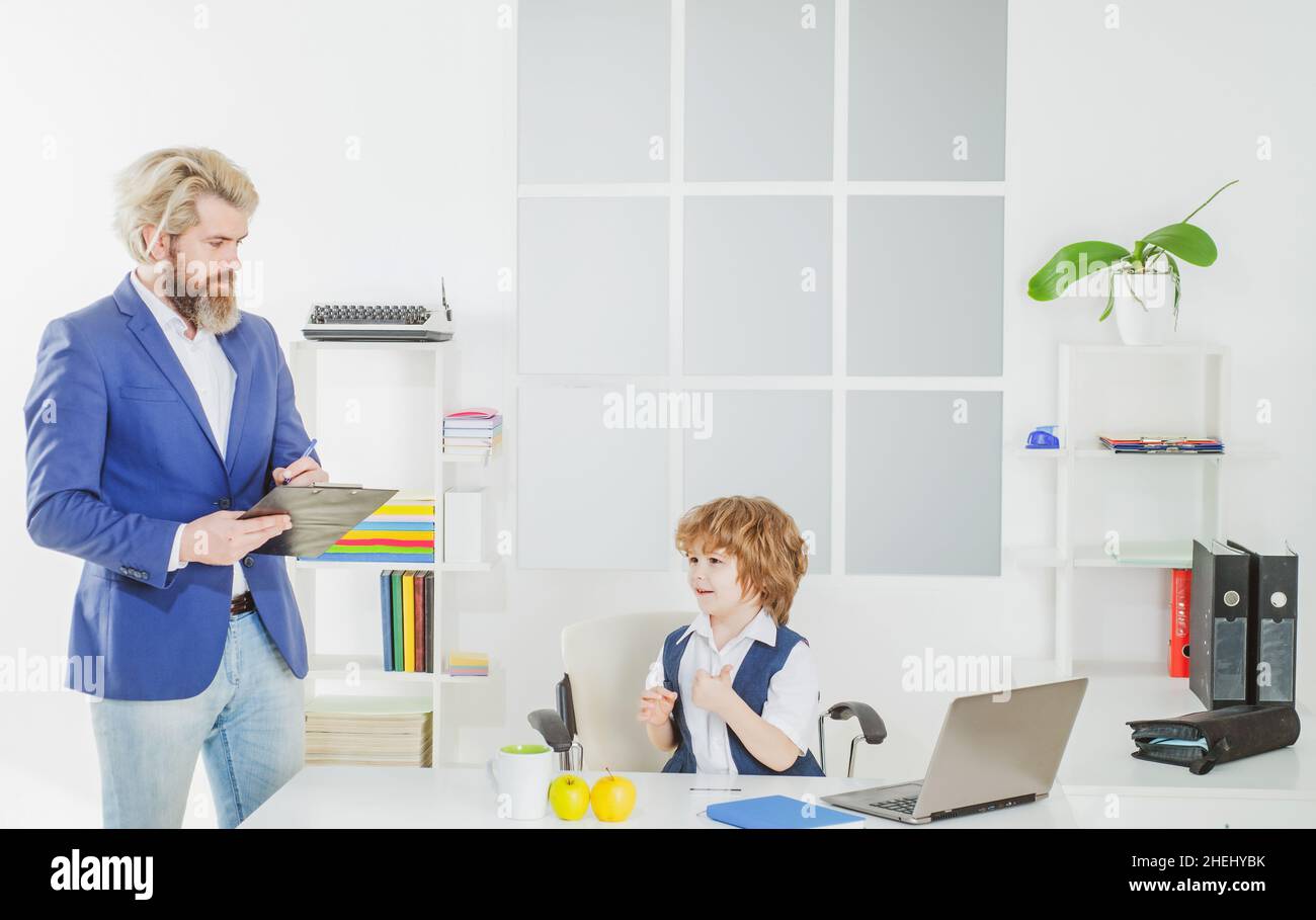 Businessman father with his son drawing on business papers at office ...
