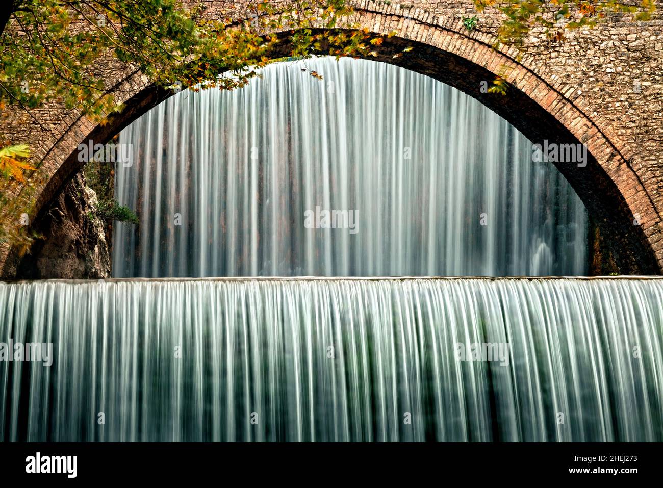 The old stone, arched bridge, between two waterfalls in Palaiokaria ...