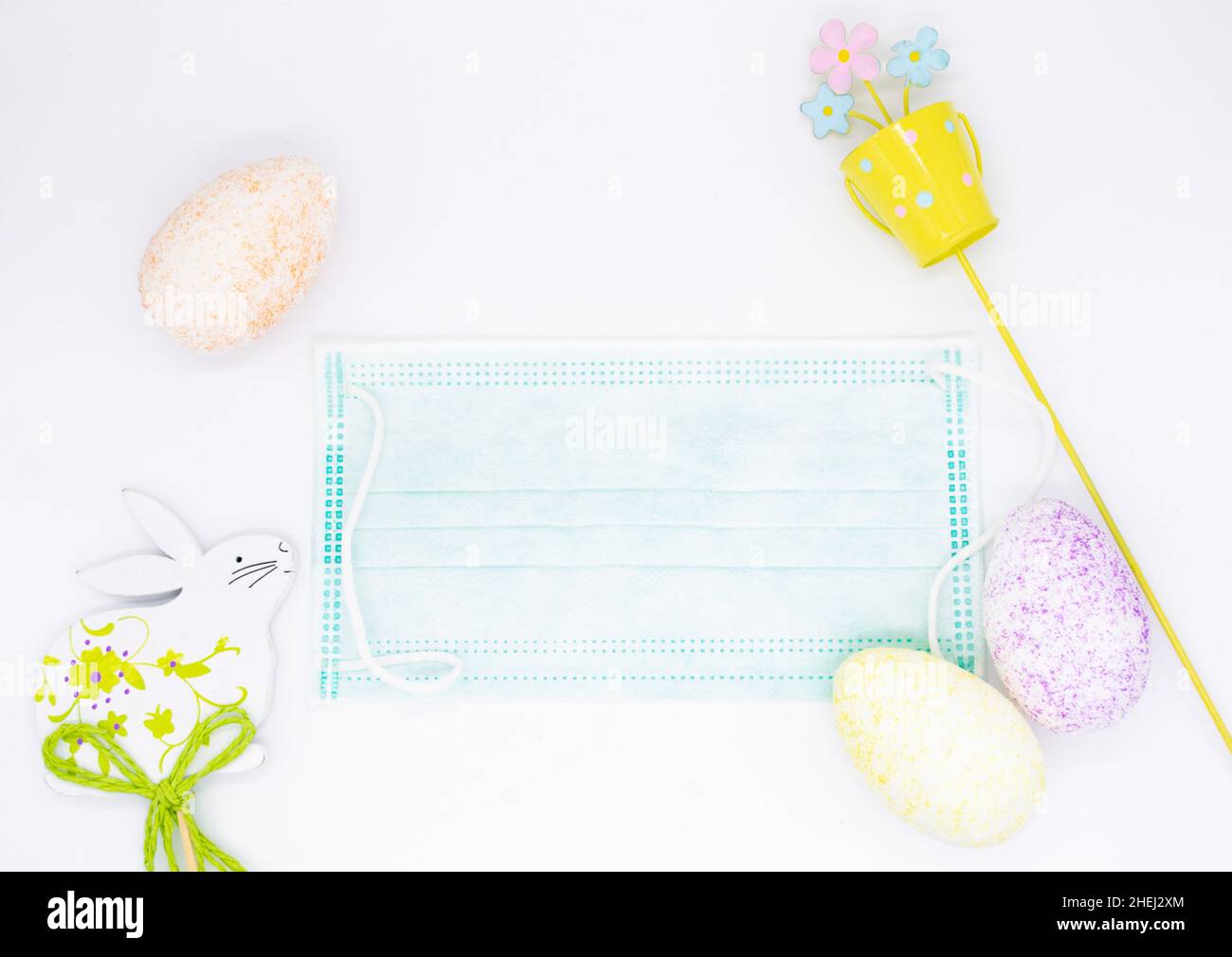Easter Flat lay with a medical face mask, colorful eggs, decorations in ...