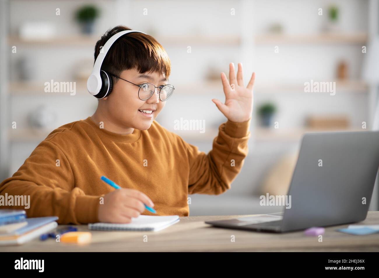 Happy asian kid having video call with teacher Stock Photo - Alamy
