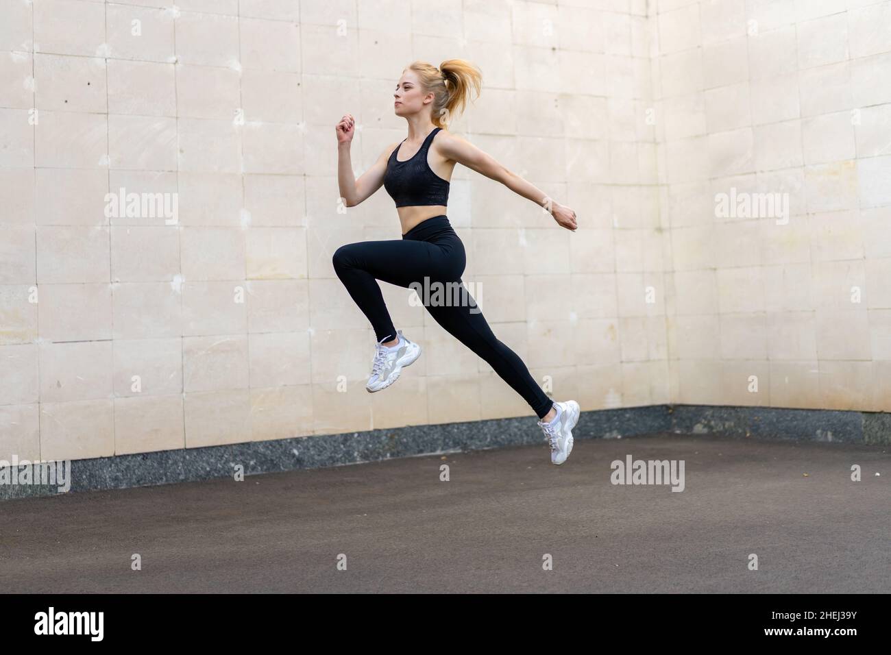 Young woman jumping concrete wall hi-res stock photography and images ...