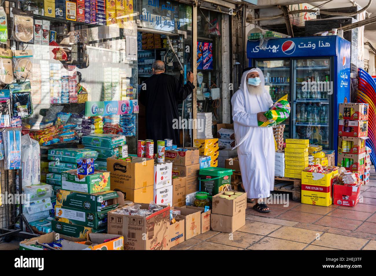 A Man In Traditional Dress Leaving A Colourful Mini Market In Aqaba ...