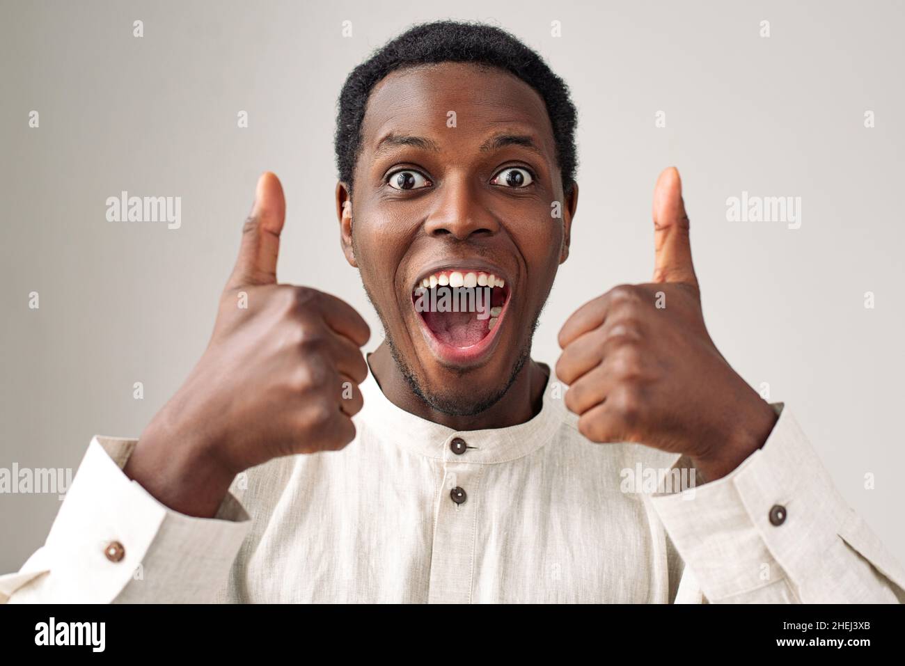Portrait of emotional happy African-American guy in white shirt showing ... Portrait of emotional happy African-American guy in white shirt showing ...