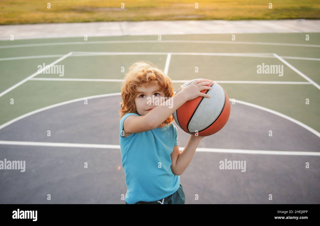 Child playing basketball. Cute little boy holding a basket ball trying ...