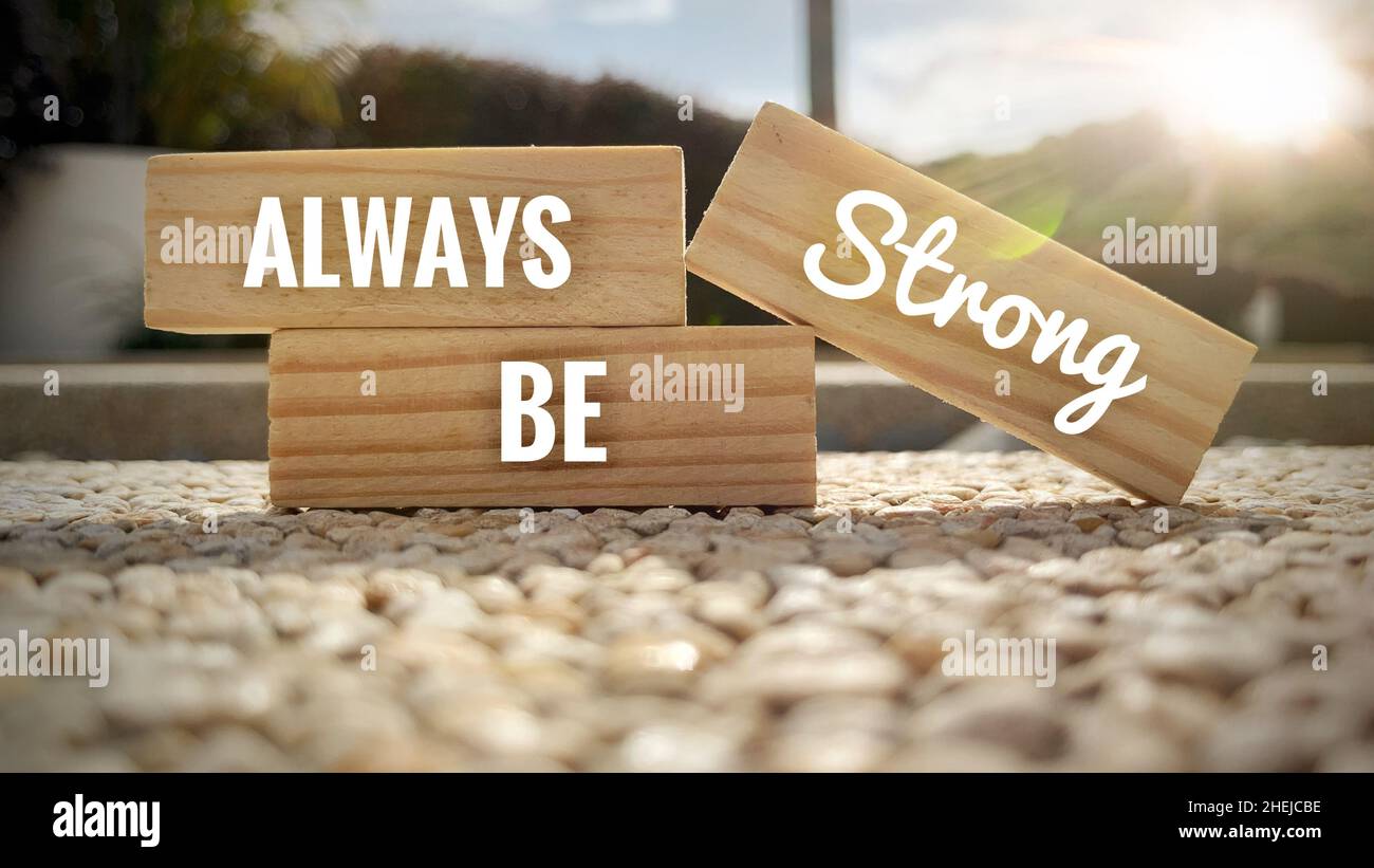 Text on wooden blocks - Always be strong. With shining light background ...