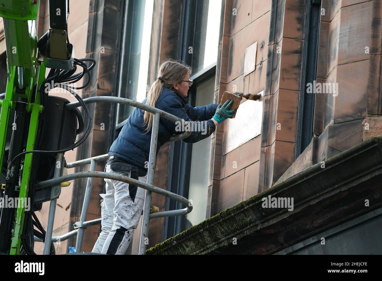 A painter on a cherry picker covers up street name signs during the set ...
