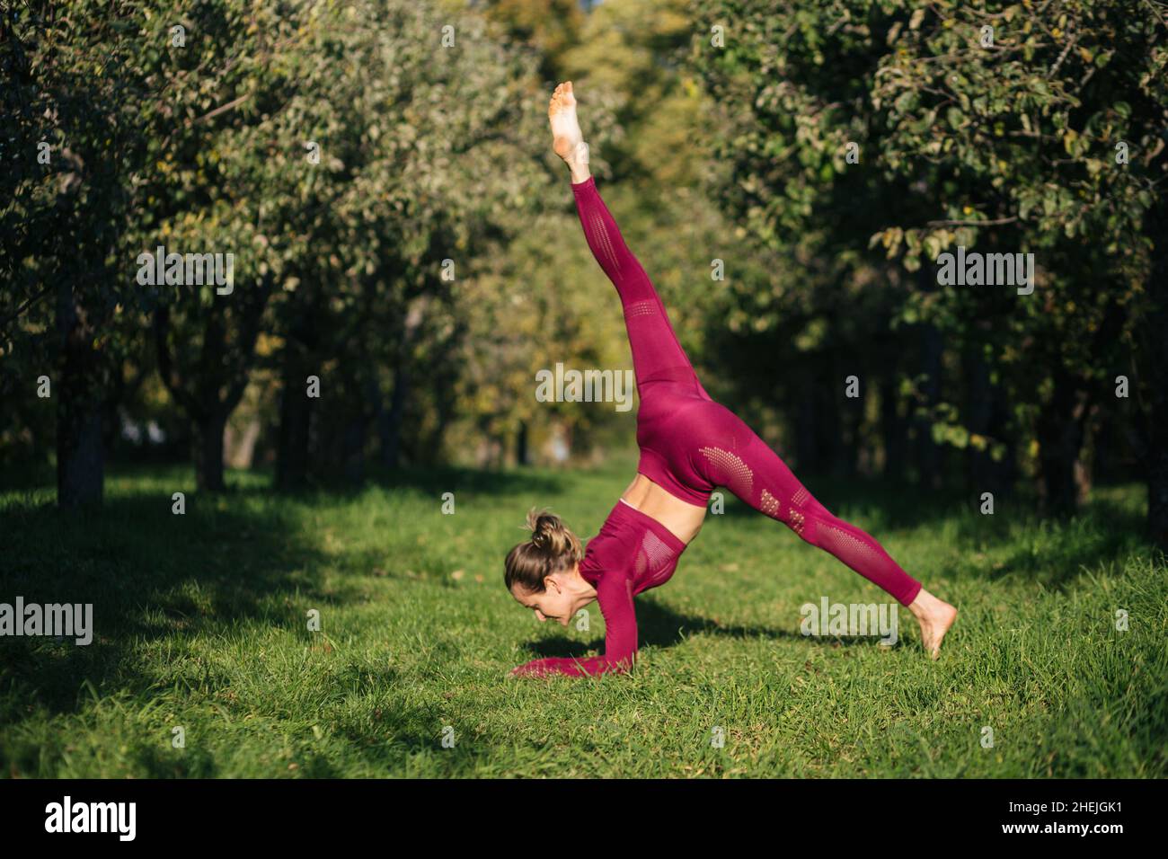 Handstand balance and split-leg by girl in red sportswear. She doing ...