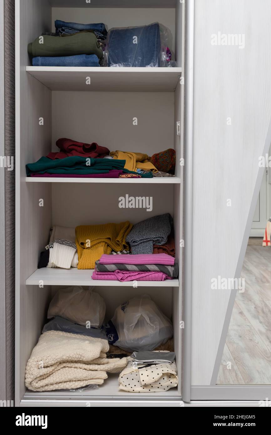 wardrobe compartment with sliding door with things on the shelves. High ...