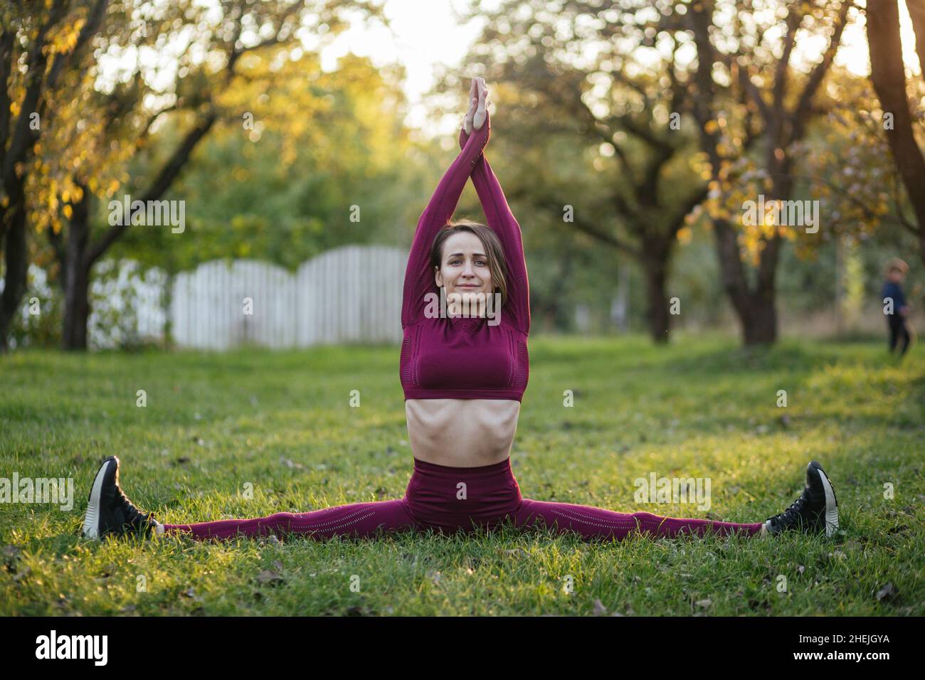 Split Leg On Sunset Girl In Red Sportswear Doing Yoga Pose In The