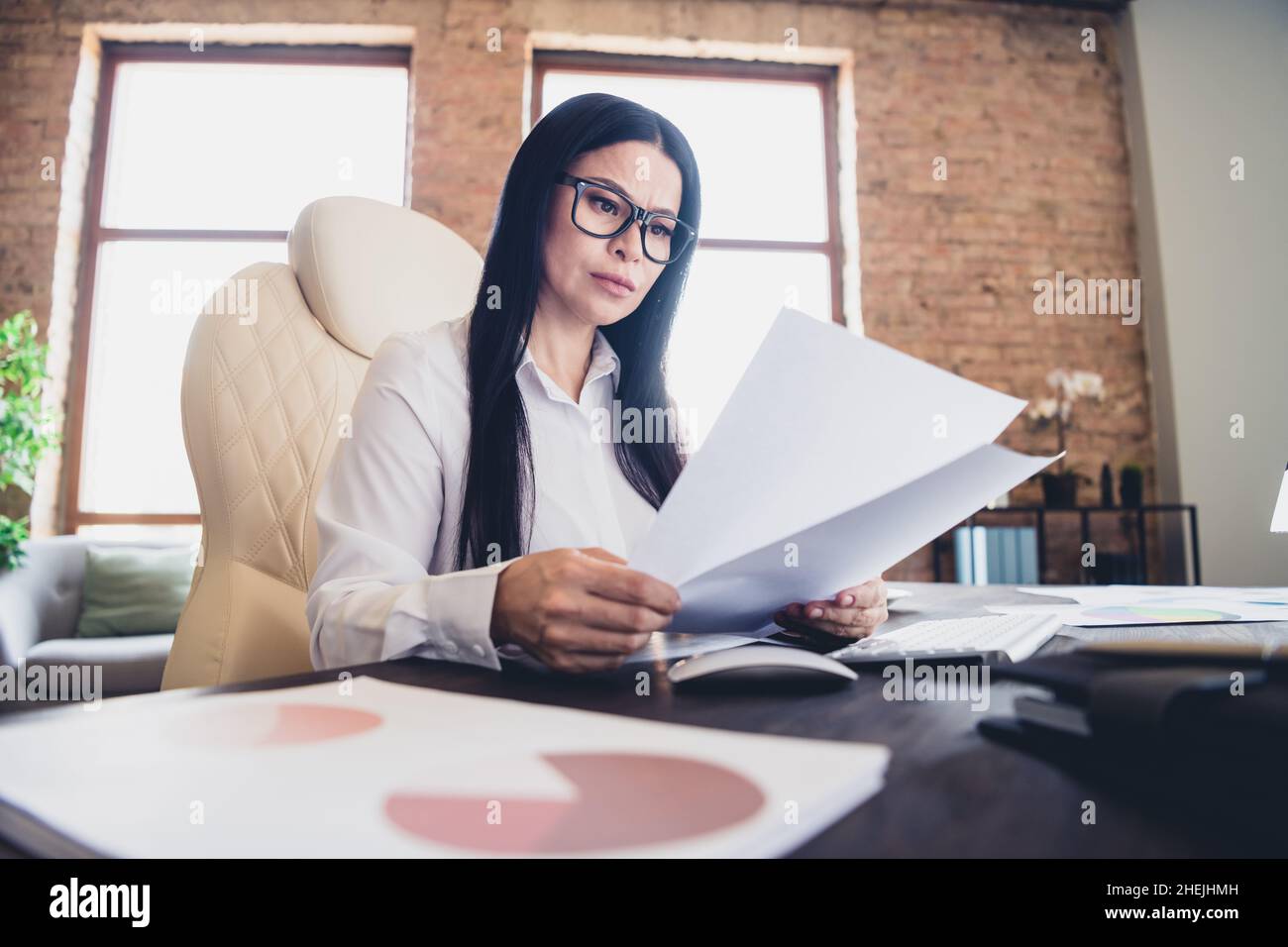 Portrait of confident successful lady sitting chair hold reading papers ...