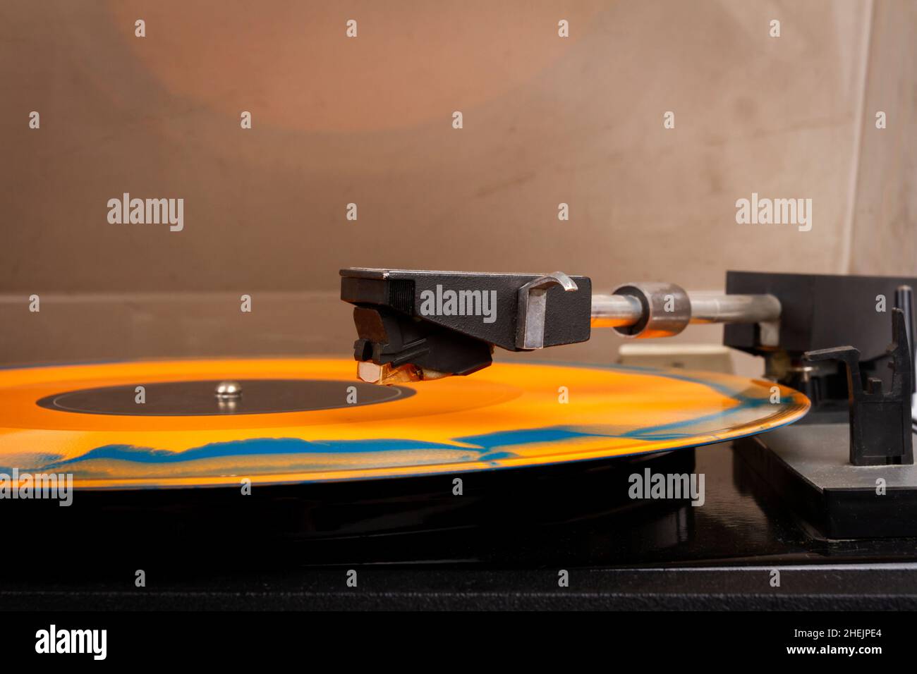Close up of vintage turntable record player with orange and blue vinyl ...