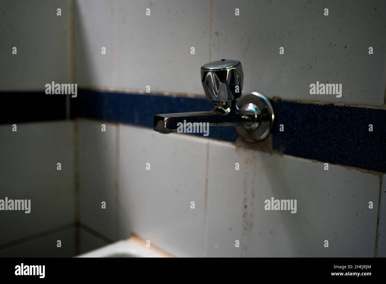 dripping, drop of water comes out of a dirty corroded metal faucet on a ...