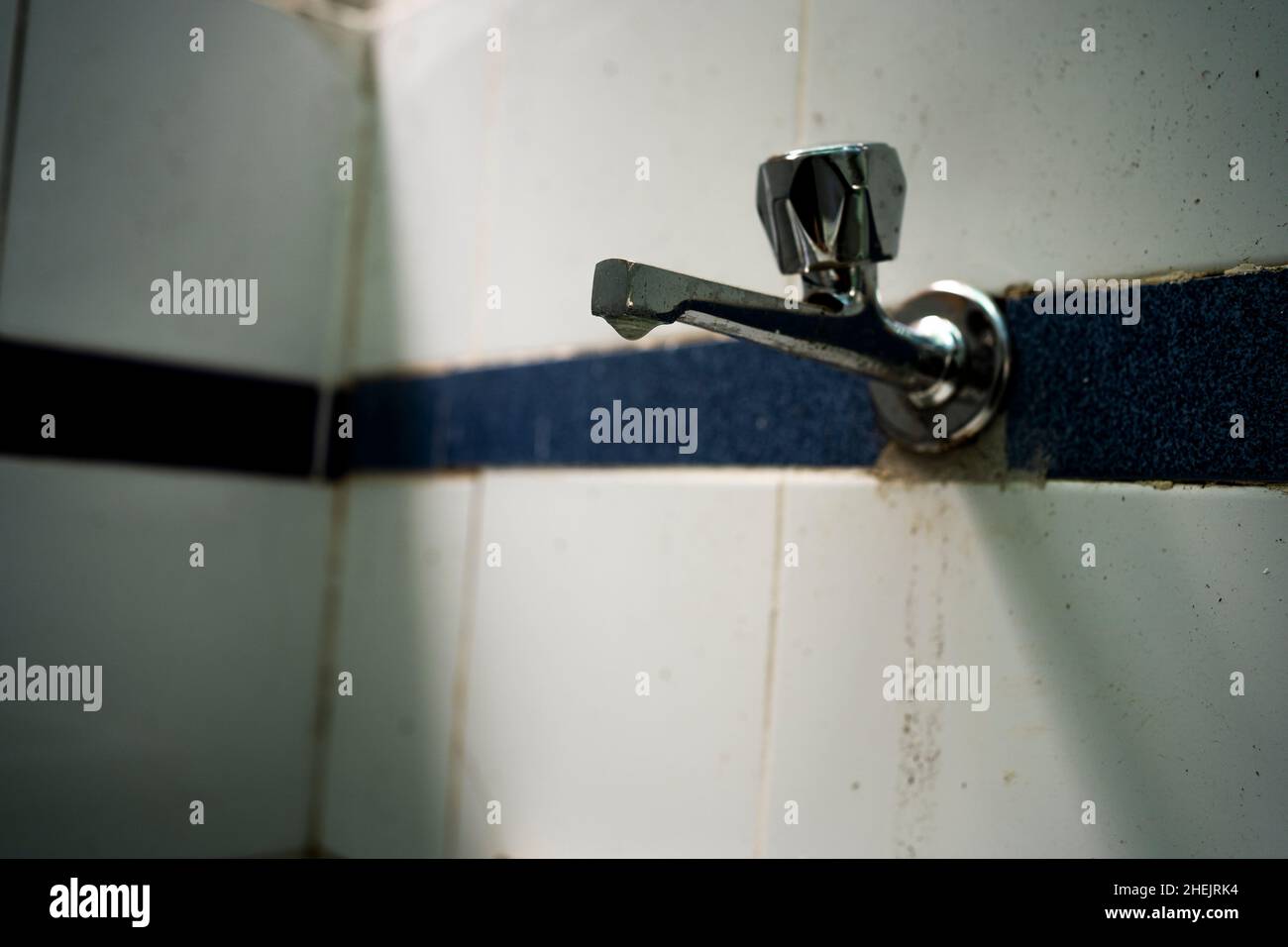 dripping, drop of water comes out of a dirty corroded metal faucet on a ...