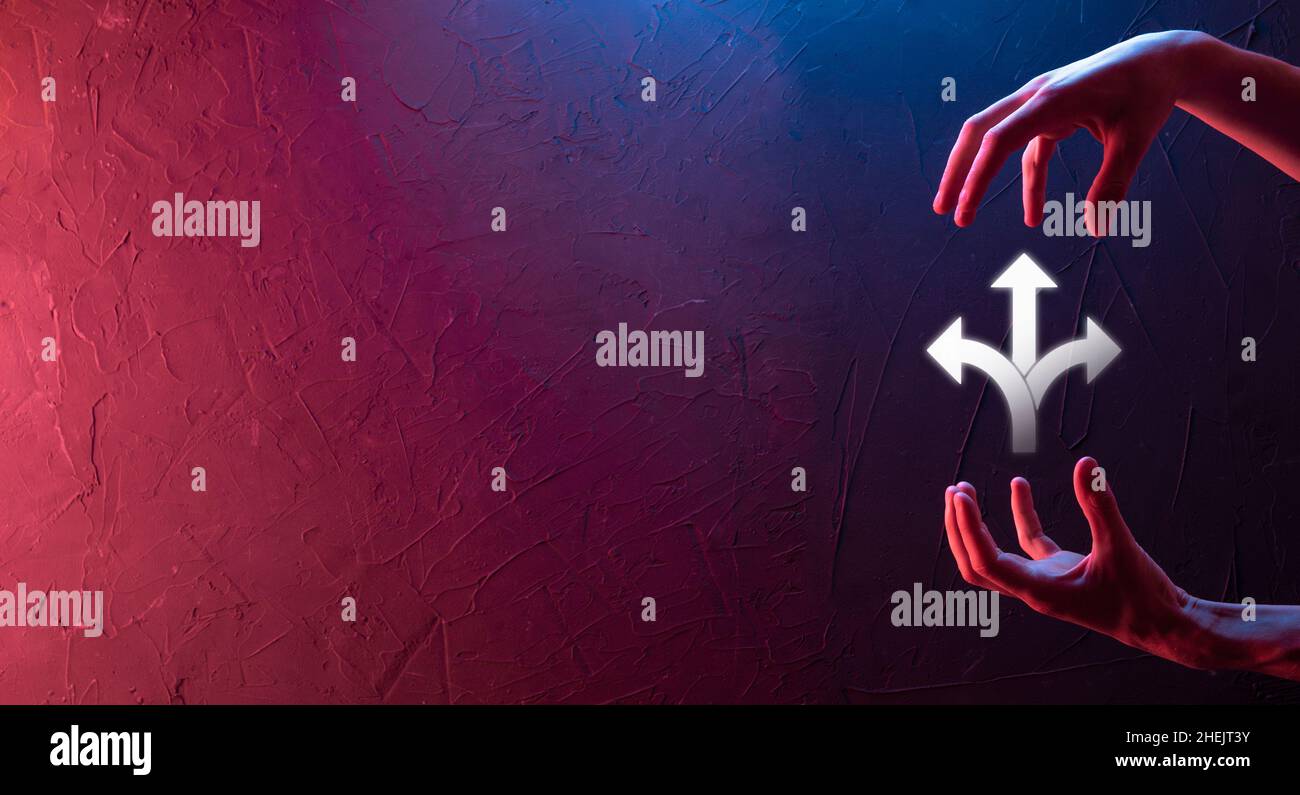 Businessman in a suit holds a sign showing three directions. in doubt ...