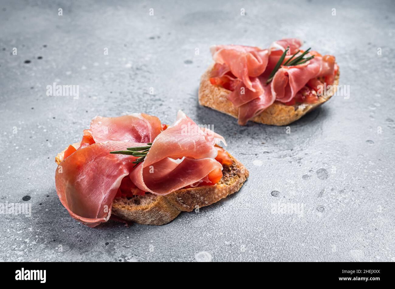 Spanish Tapas with tomatoes and cured Slices of jamon iberico ham ...