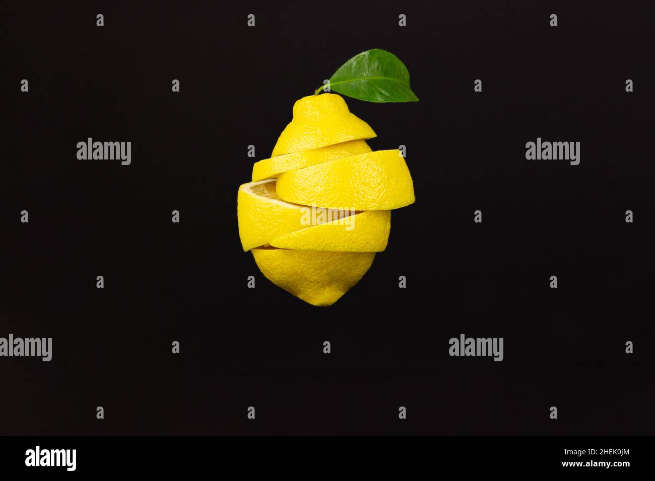 A cut lemon in levitation flies slices freely on brown background ...