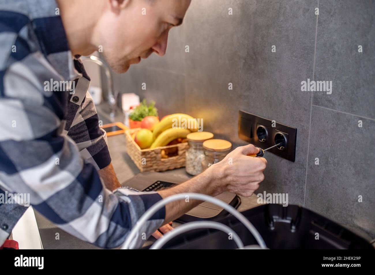 Close-up photo of man touching socket with screwdriver Stock Photo - Alamy