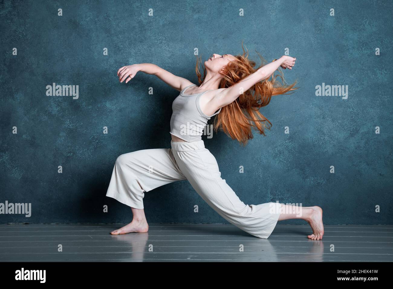 Petitie dancer with red auburn hair dancing against grey backdrop Stock ...