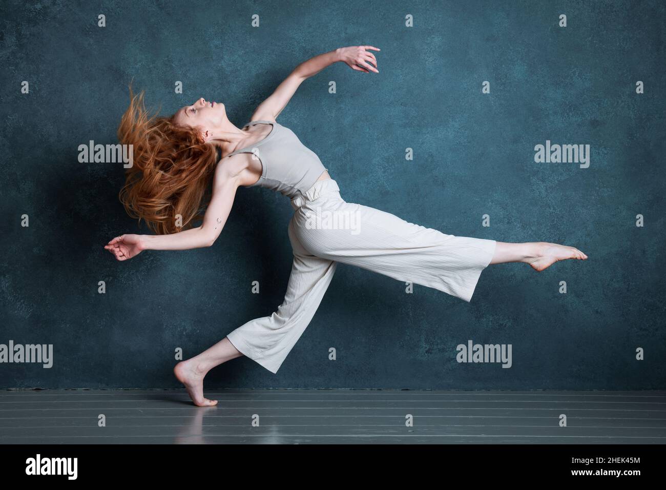 Petitie dancer with red auburn hair dancing against grey backdrop Stock ...