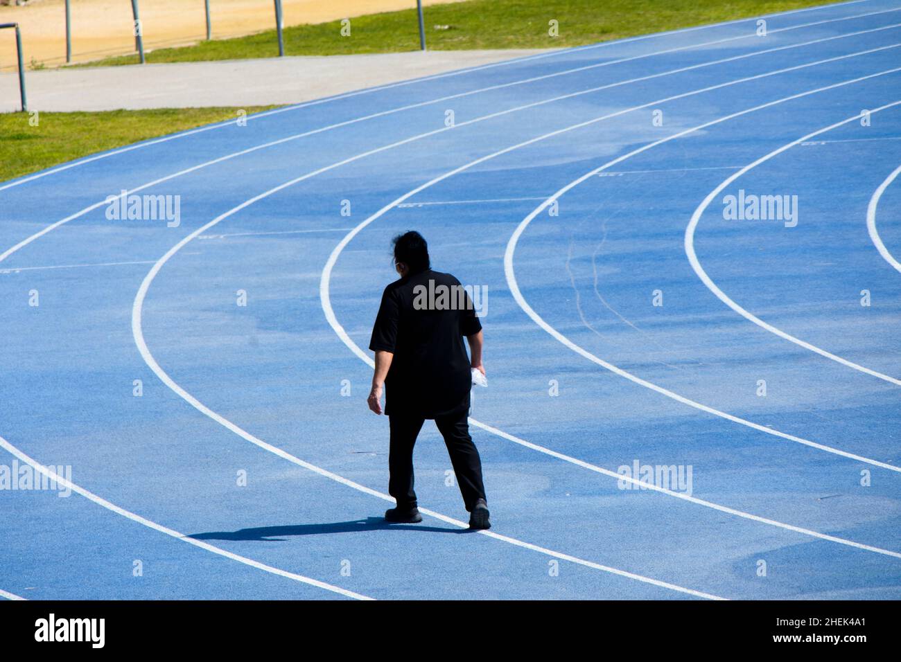 Worker walking in a running track Stock Photo - Alamy