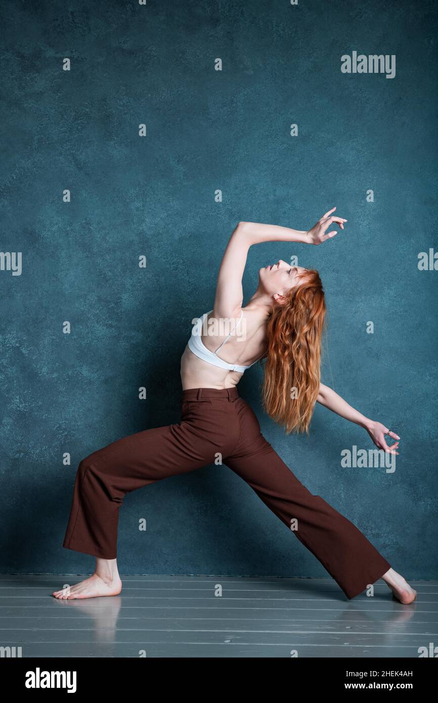 Petitie dancer with red auburn hair dancing against grey backdrop Stock ...