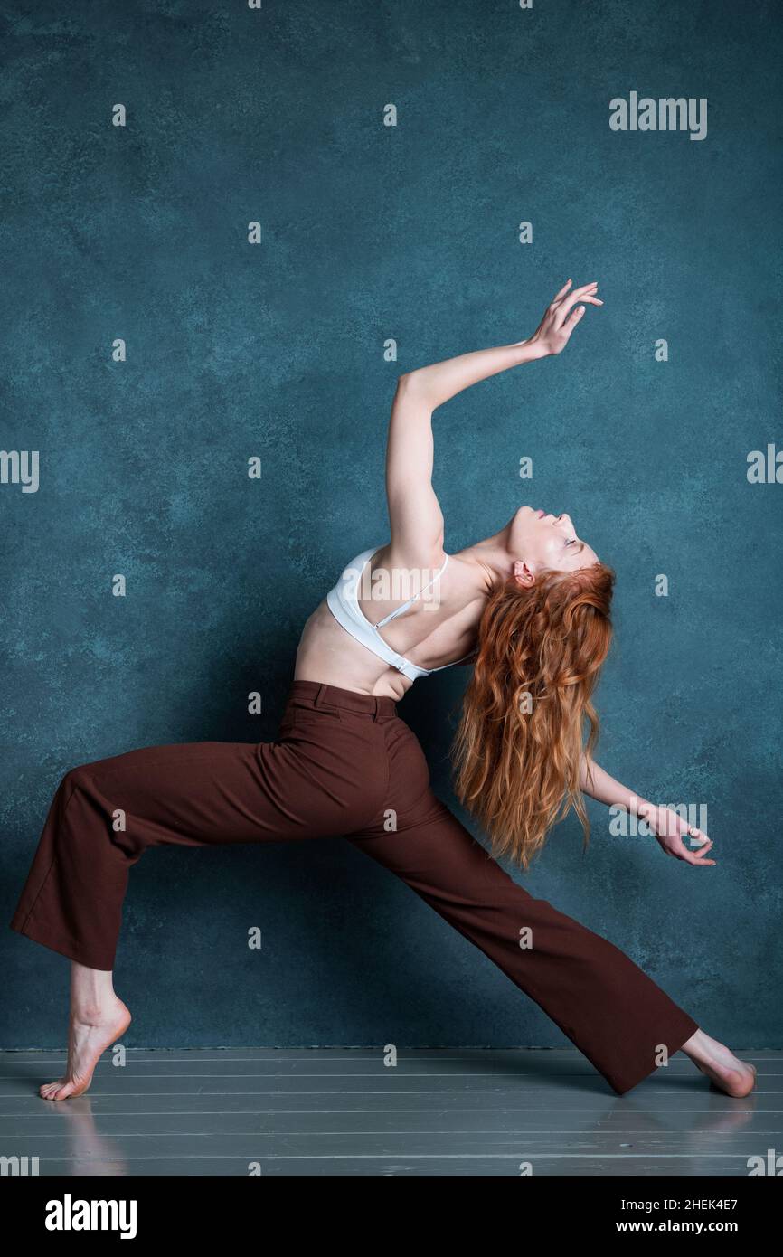 Petitie dancer with red auburn hair dancing against grey backdrop Stock ...