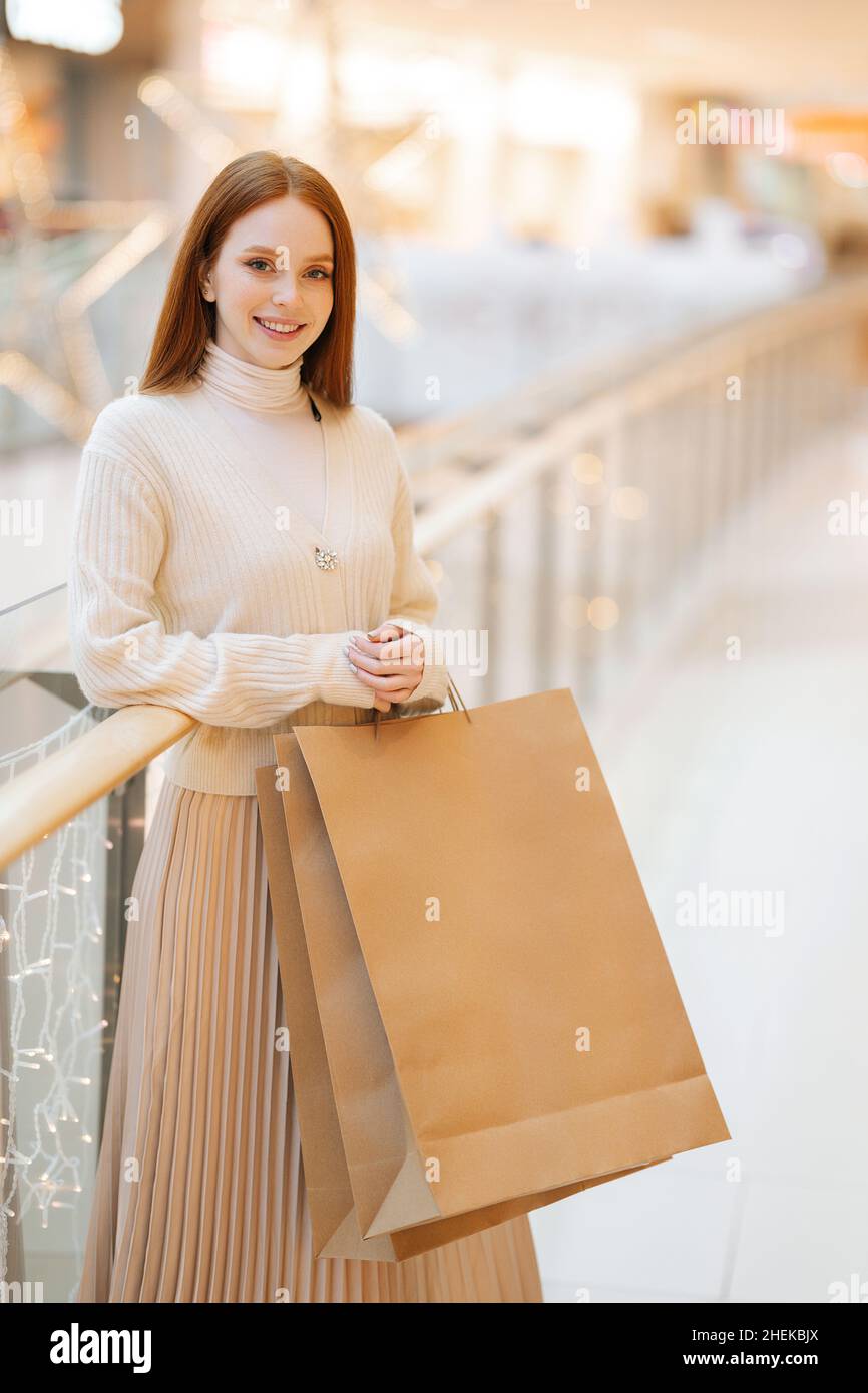 Vertical portrait of smiling charming young woman holding in hands ...