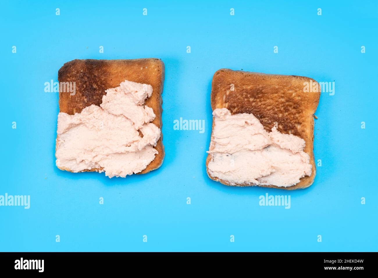 Two toasts with cream spread on a blue background. Food concept. Fish ...