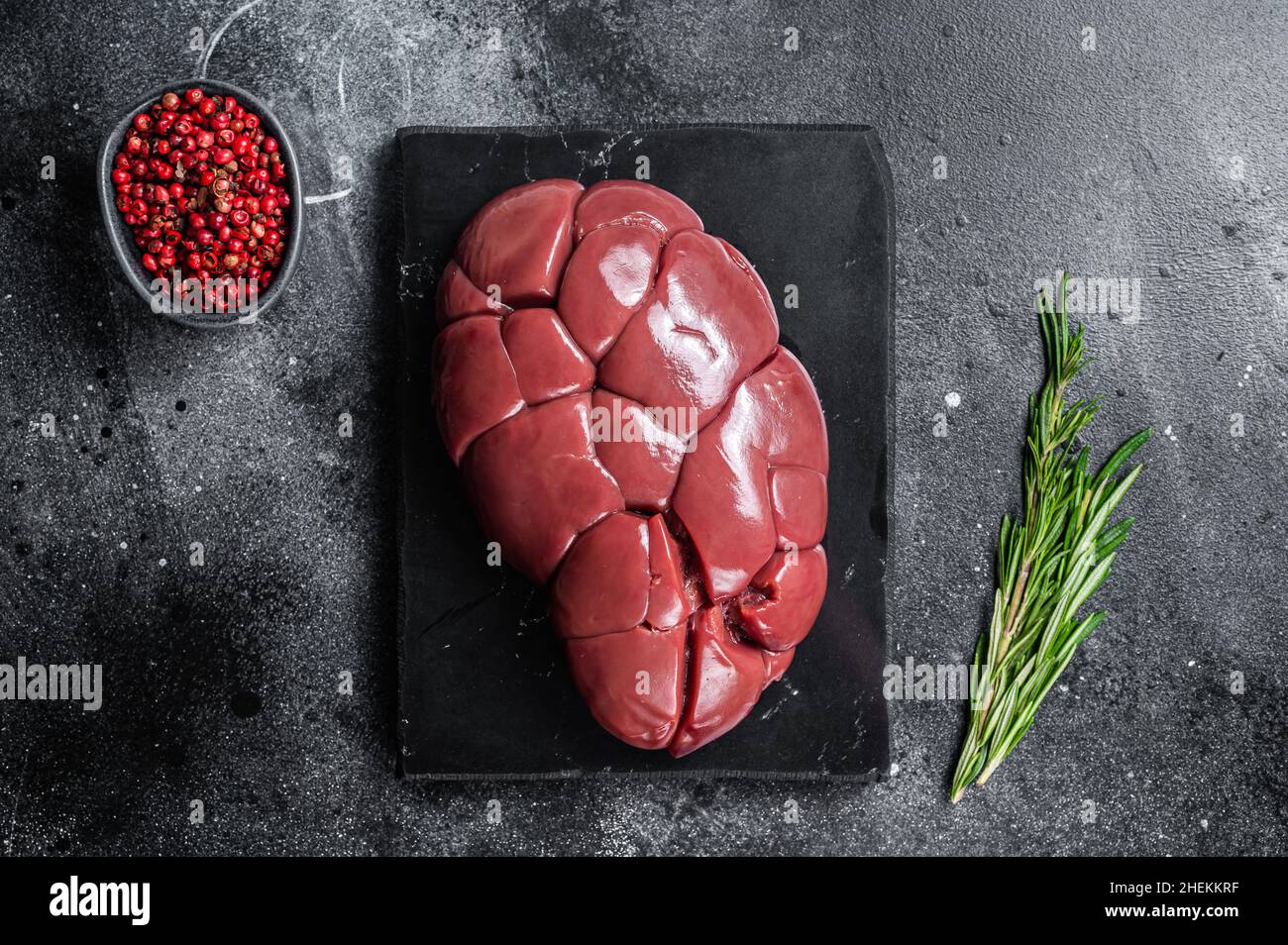Beef veal kidney, raw offal meat on marble board with rosemary. Black ...