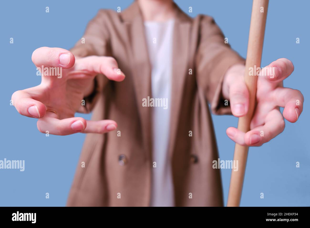 Woman teacher pulls her hands forward and wants to grab on studio blue ...