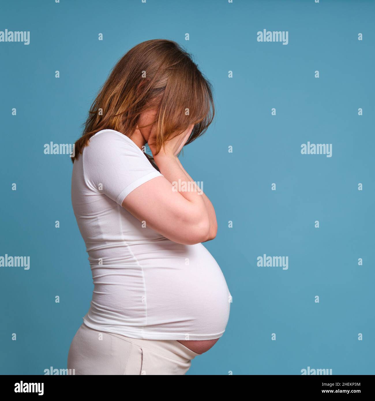 Problems and diseases during pregnancy in women, studio blue background ...