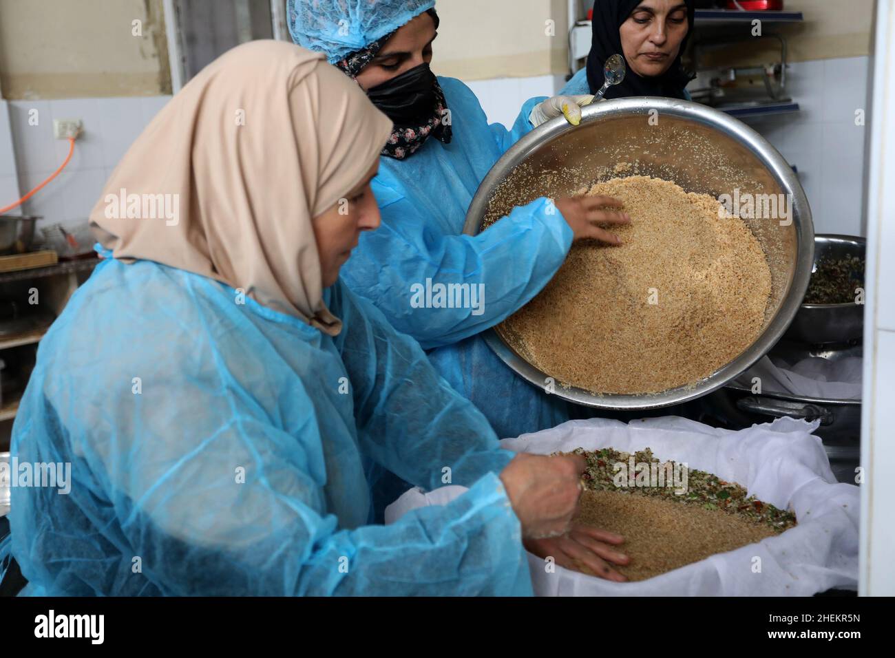 Palestinian women prepare "Maftoul", a traditional couscous dish made ...