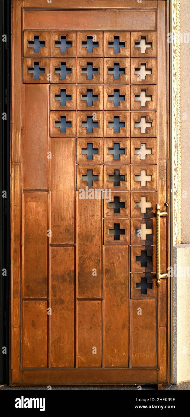 Metal vintage door to a catholic church. The door has holes in the form ...